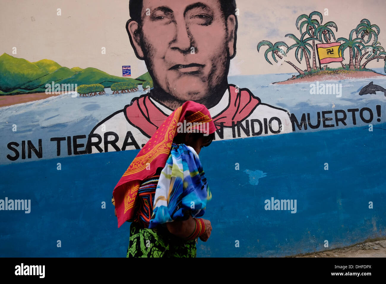 A woman from the Guna people walks past a painted wall depicting 1925 ...