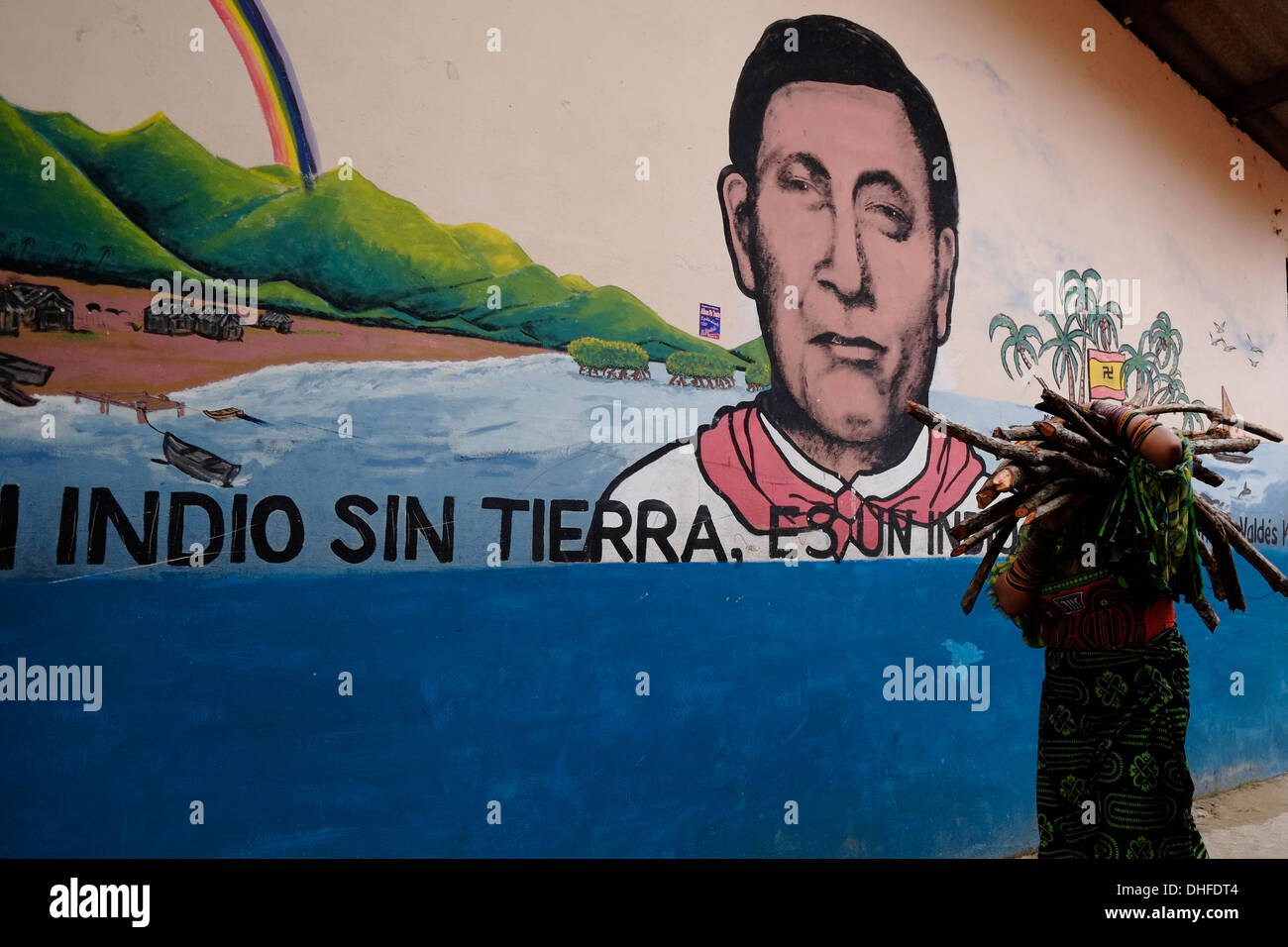 A woman from the Guna people carrying a bundle of sticks walks past a ...