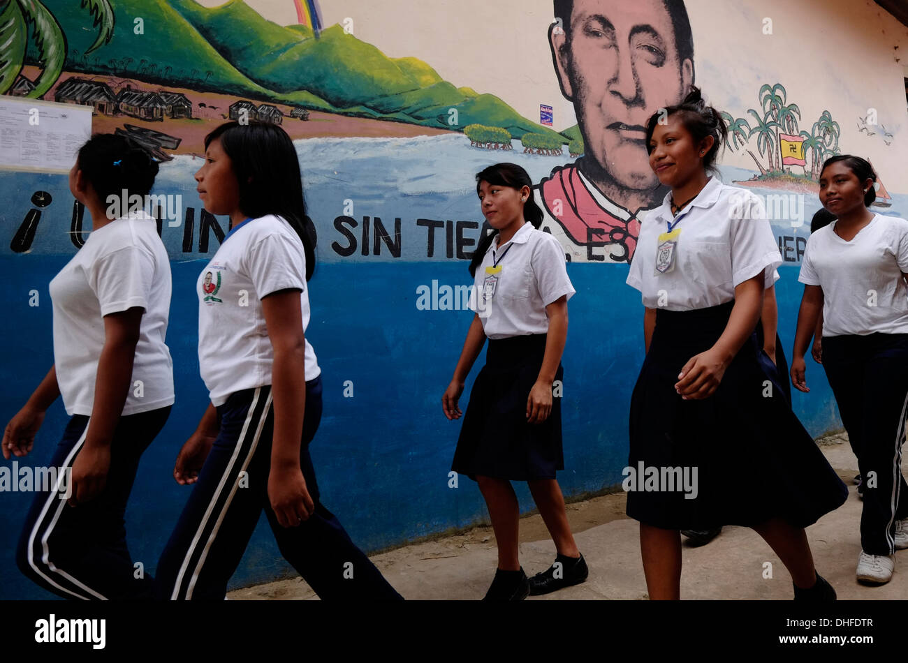 Schoolgirls from the Guna people walk past a painted wall depicting ...
