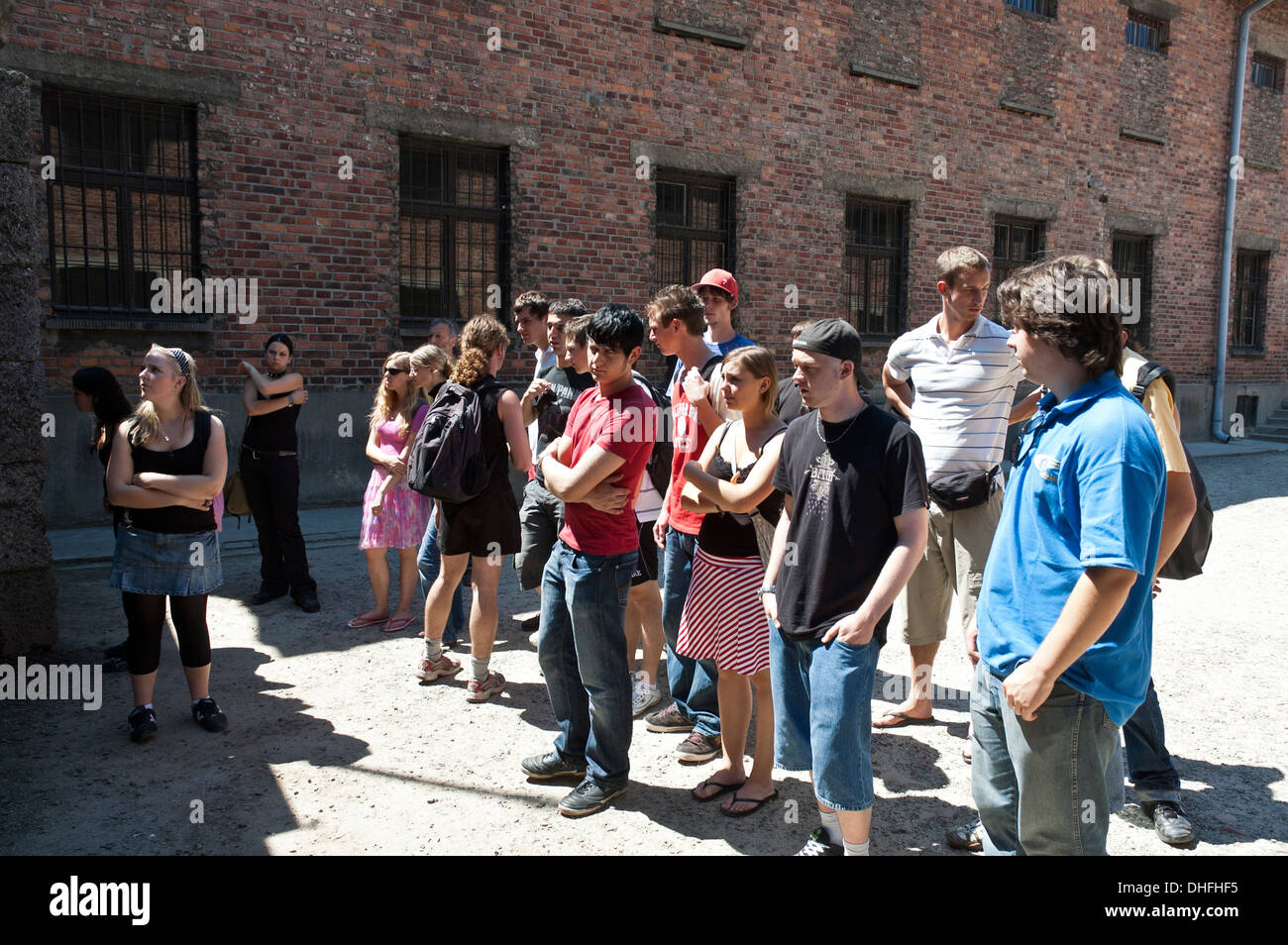 Young visitors looking at the execution wall in Auschwitz concentration ...