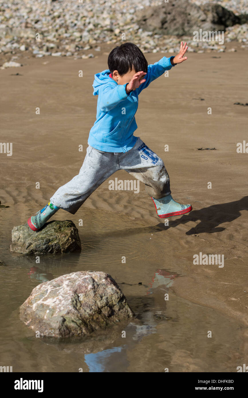 Young Boy playing in the rock pools at the beach Stock Photo - Alamy