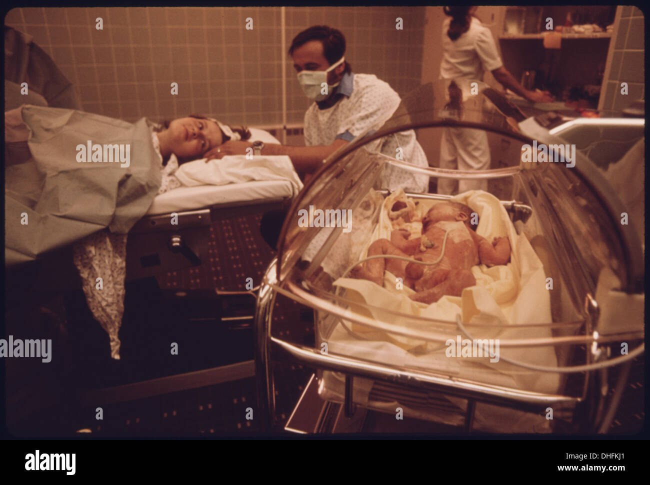 The image shows a woman who has just given birth in the delivery room ...