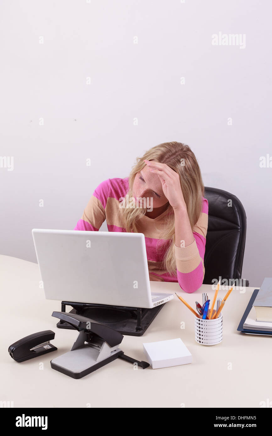 Young woman with headache sitting at computer Stock Photo - Alamy
