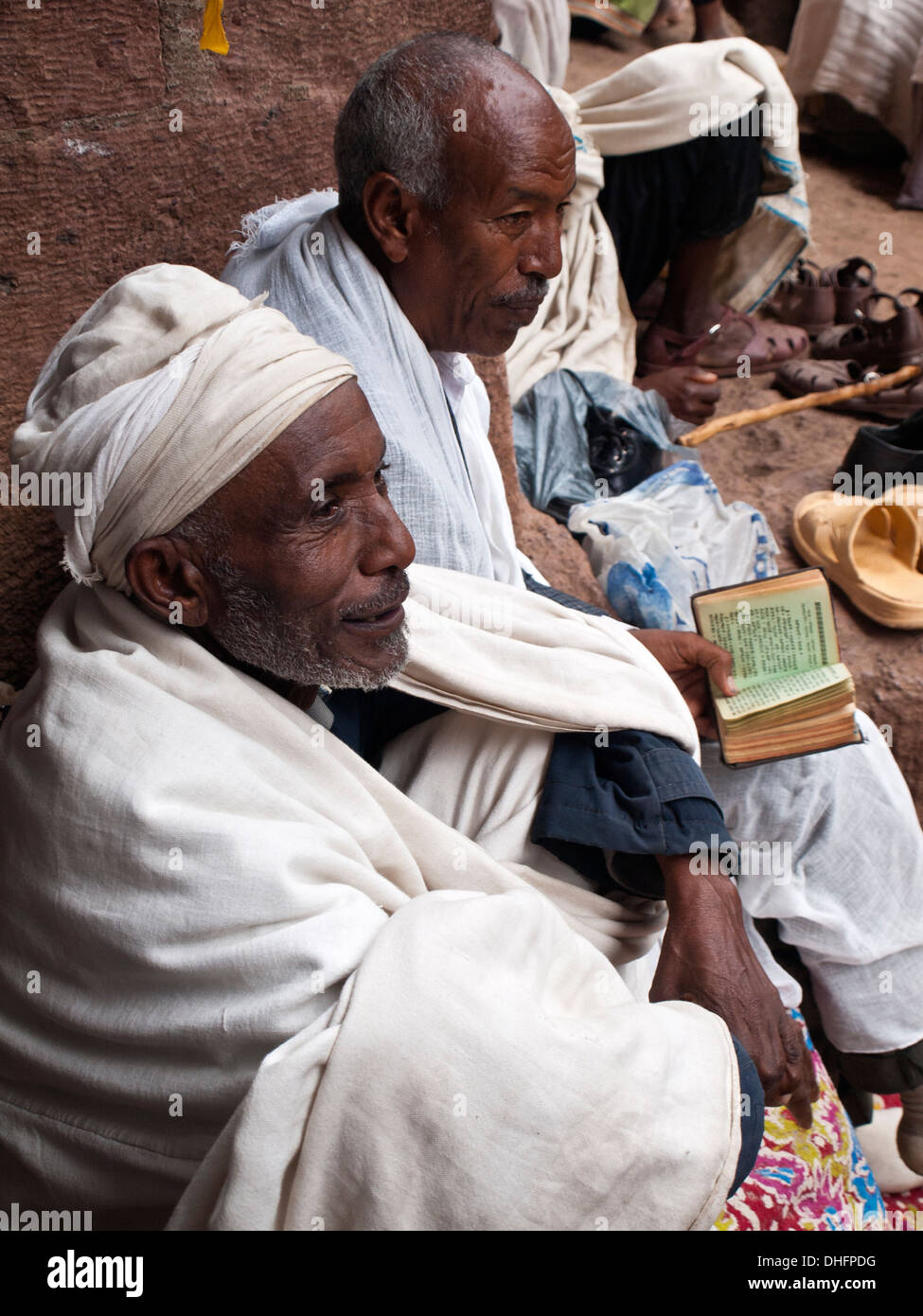 Two pilgrims read the Bible outside church in Lalibela Stock Photo - Alamy