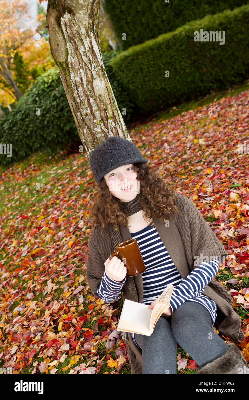 Vertical photo of teenage girl, looking forward, enjoying her book, and ...