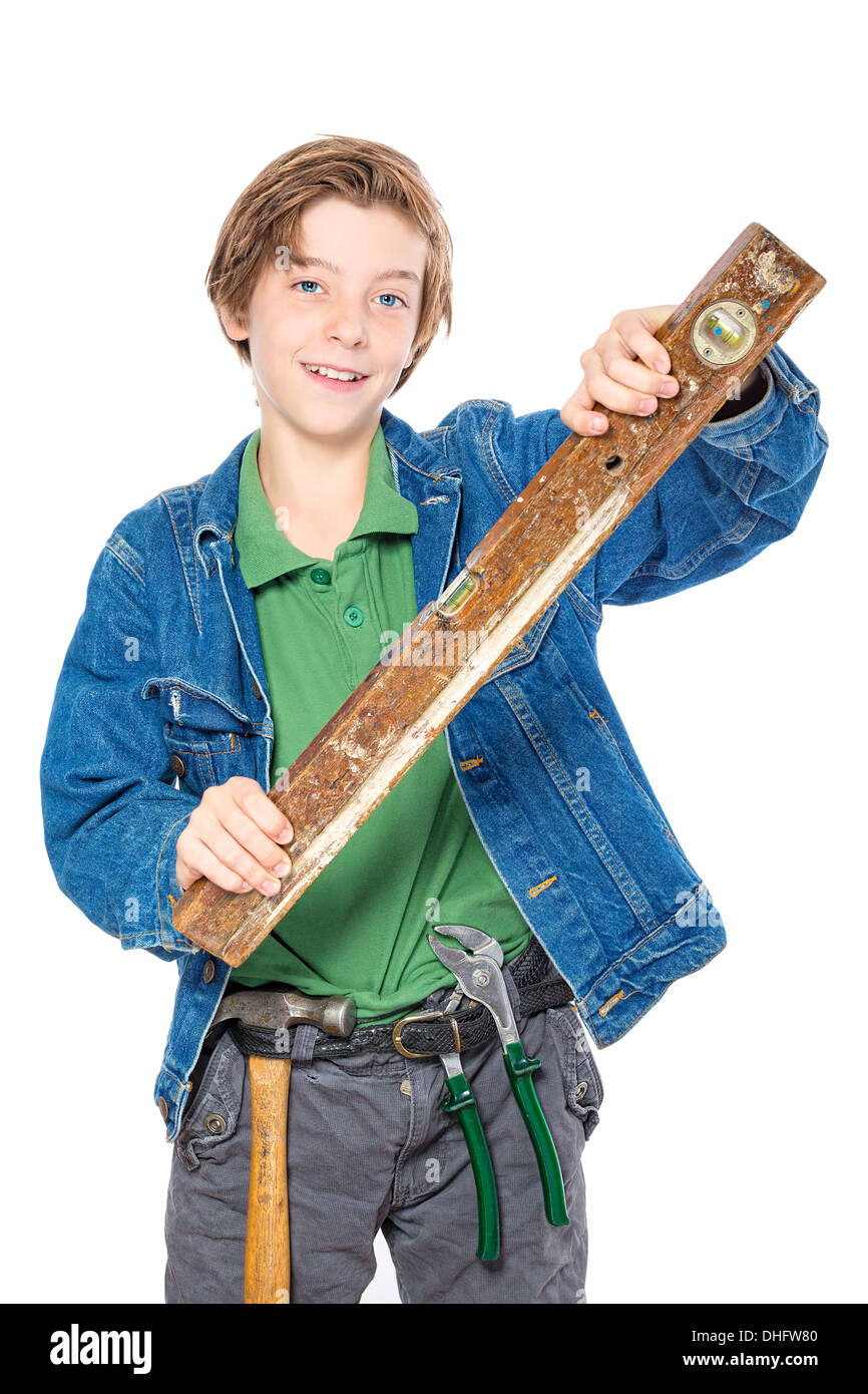 smiling boy with tool in his belt holding a water level in his hands ...