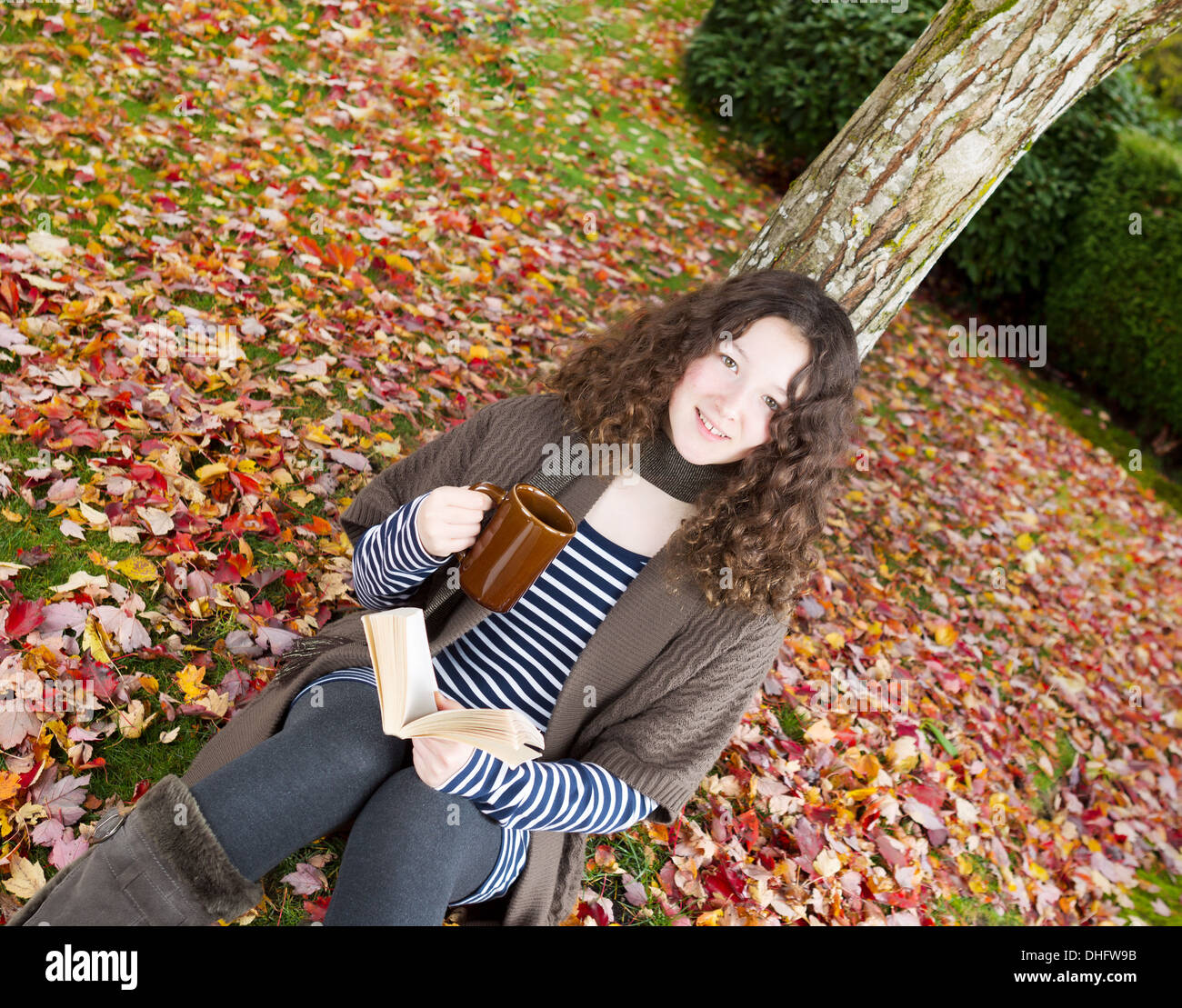 Horizontal photo of teenage girl, looking forward, enjoying her book ...