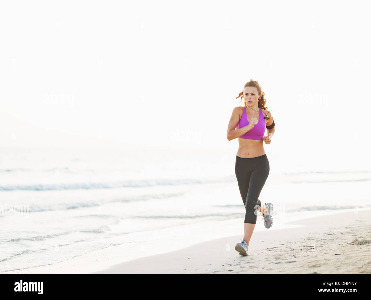 Healthy young woman running on beach Stock Photo - Alamy