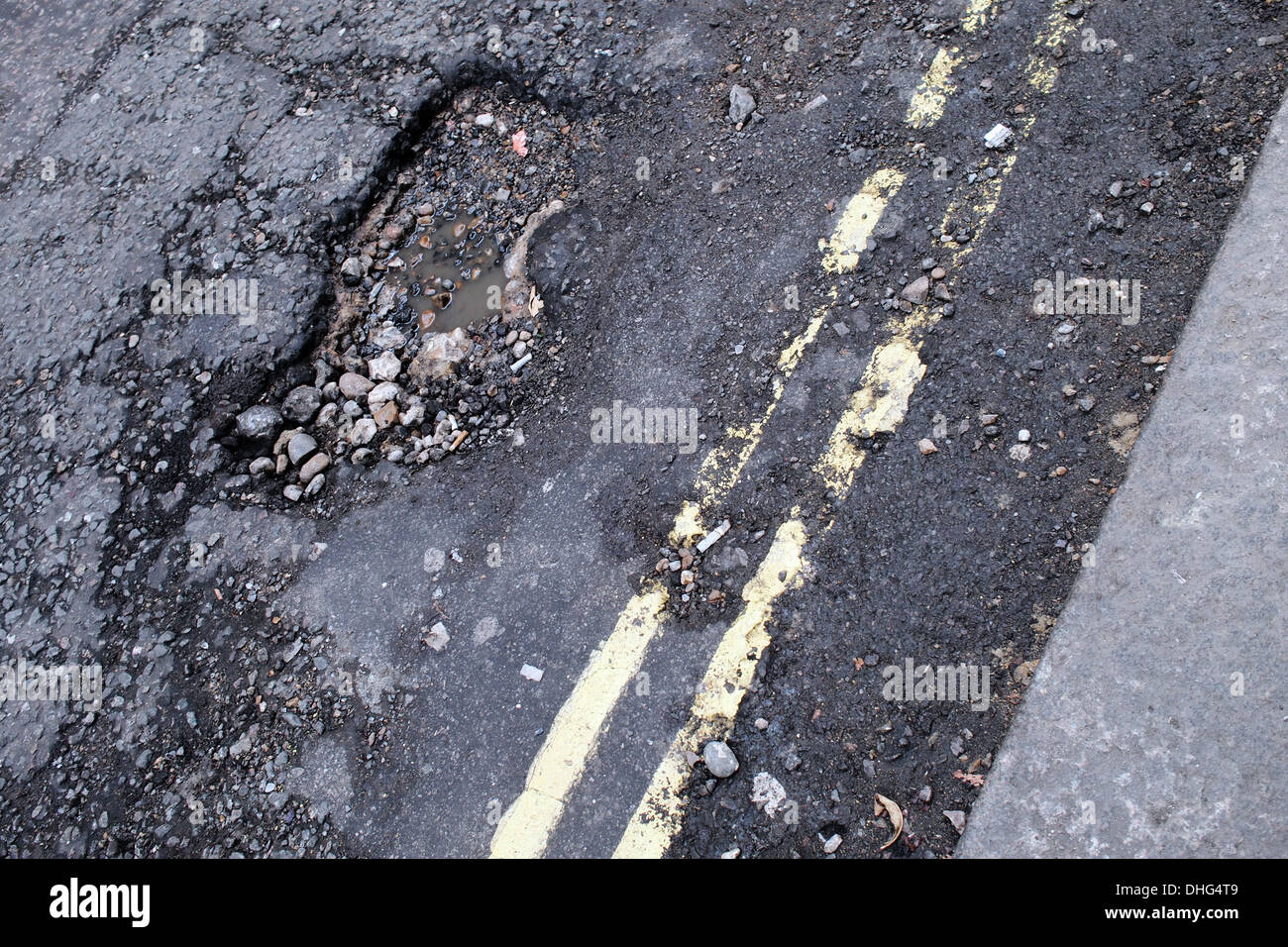Pothole road damage on London road street driving Stock Photo - Alamy