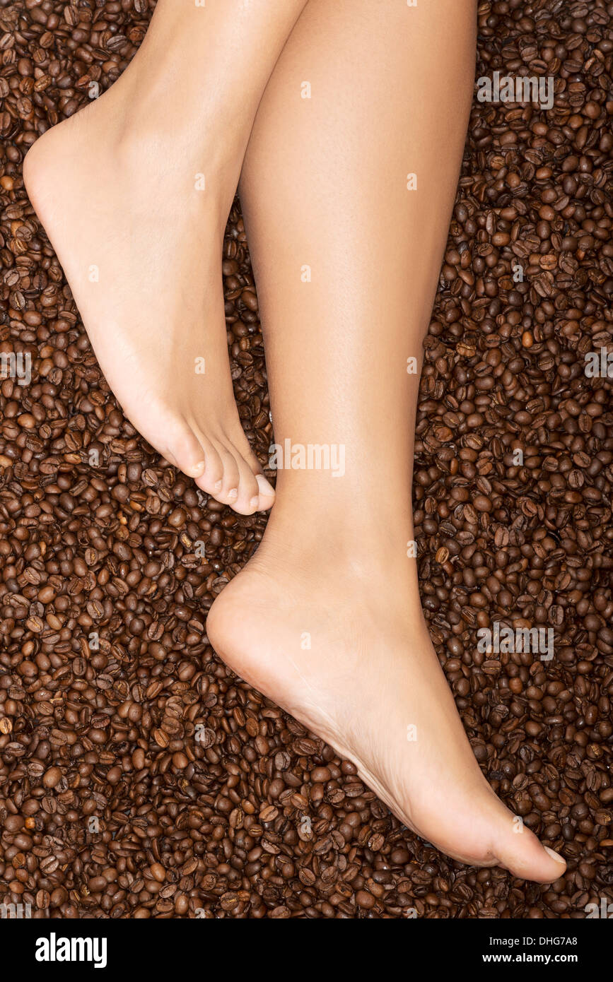 Female legs on coffee seeds. Closeup Stock Photo - Alamy