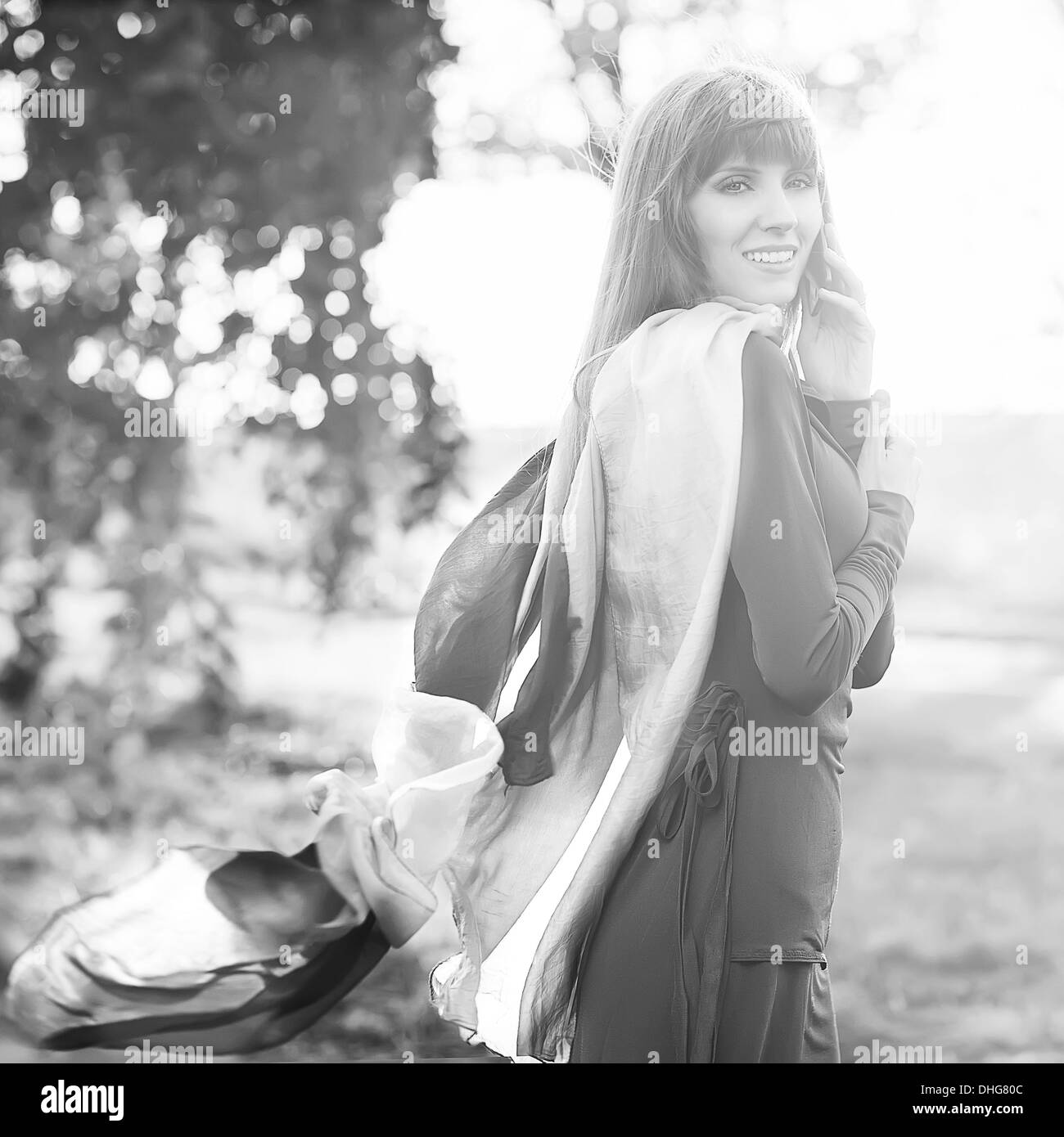 beautiful girl talking on the phone, her scarf is developing the wind ...