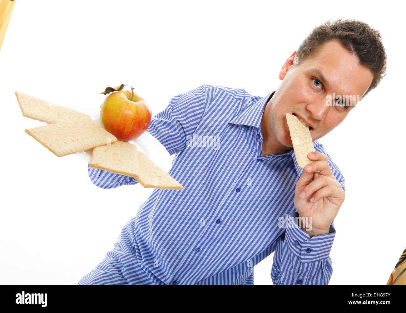 Young slim man eating crispbread and offering you plate with apple and ...