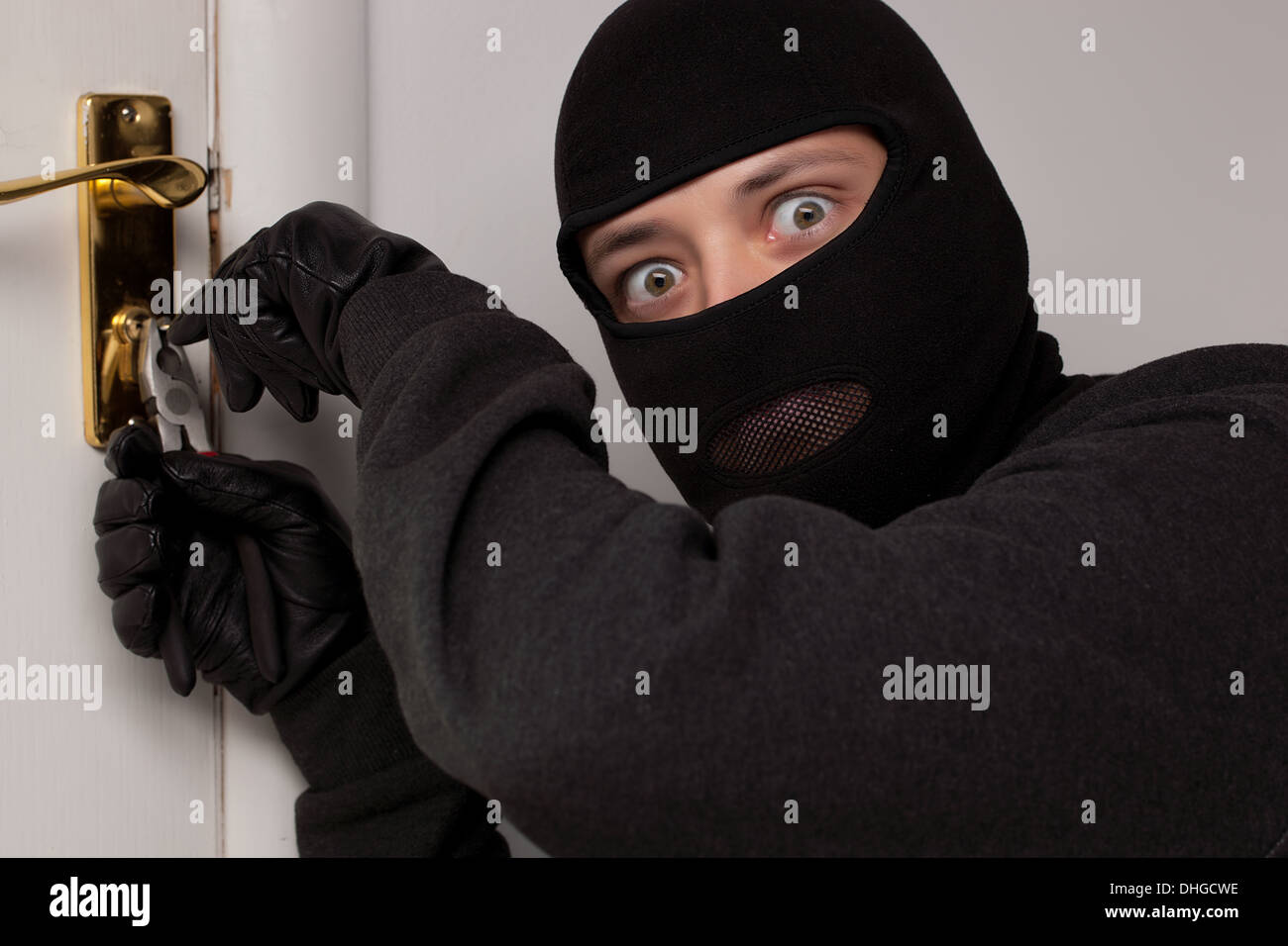 Thief Burglar opening door Stock Photo - Alamy