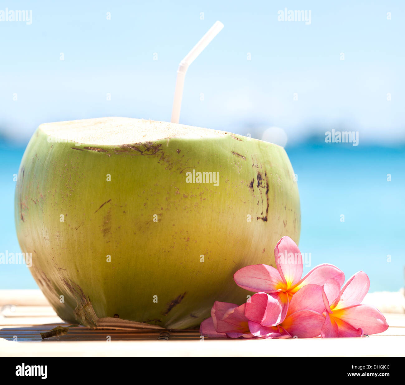 Tropical fresh coconut cocktail decorated plumeria on white beach Stock ...
