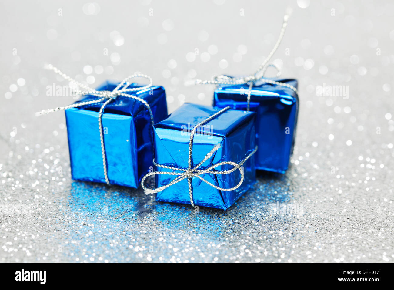 Blue Christmas gift boxes on shiny silver background Stock Photo - Alamy