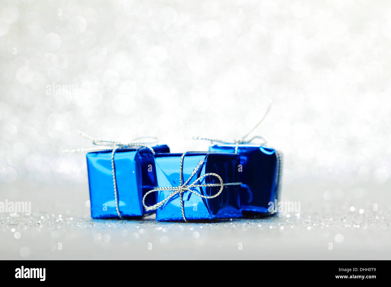 Blue Christmas gift boxes on shiny silver background Stock Photo - Alamy