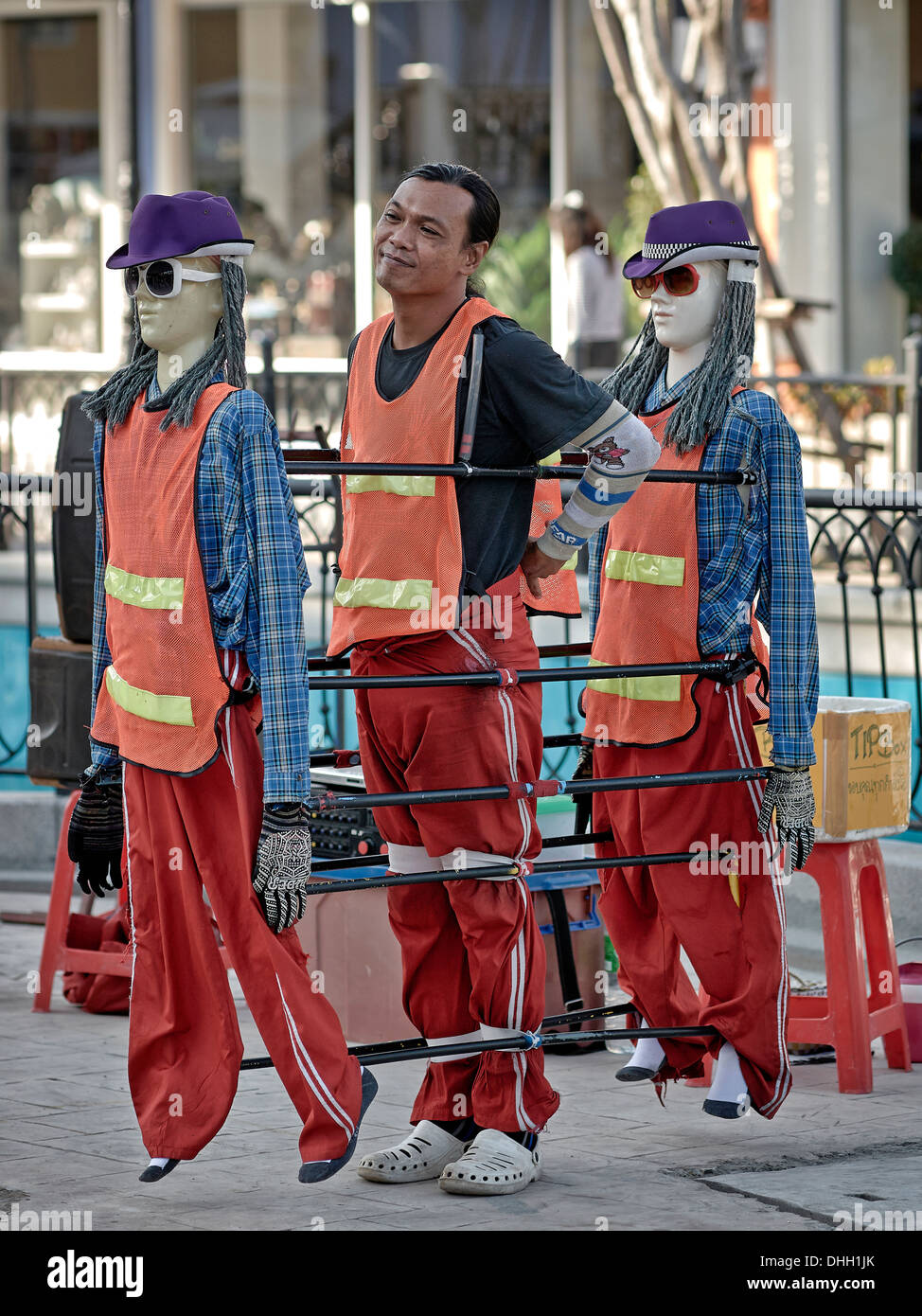Street entertainer with synchronized mannequins preparing to perform a ...