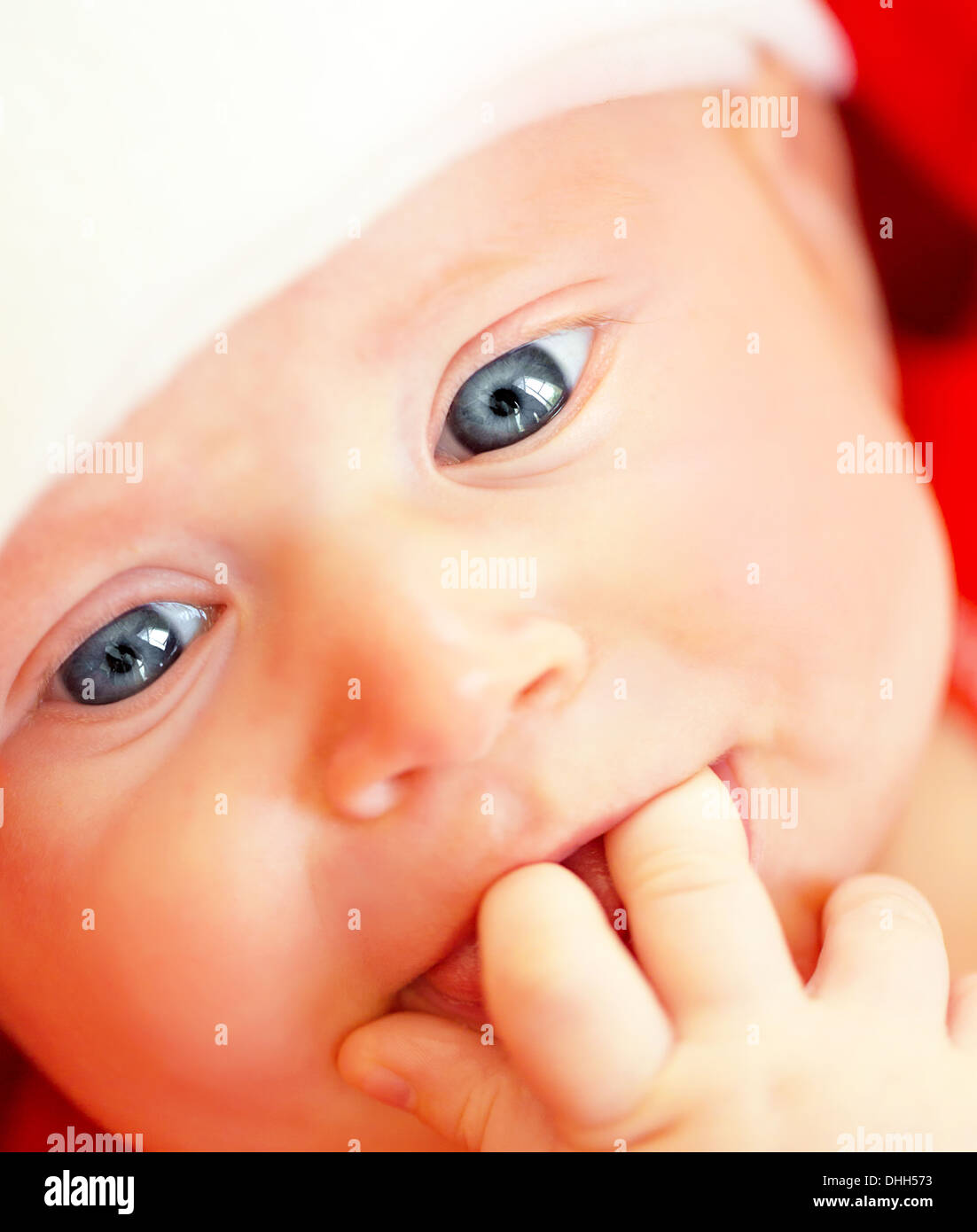 Closeup portrait of cute newborn baby with two fingers in mouth, funny ...