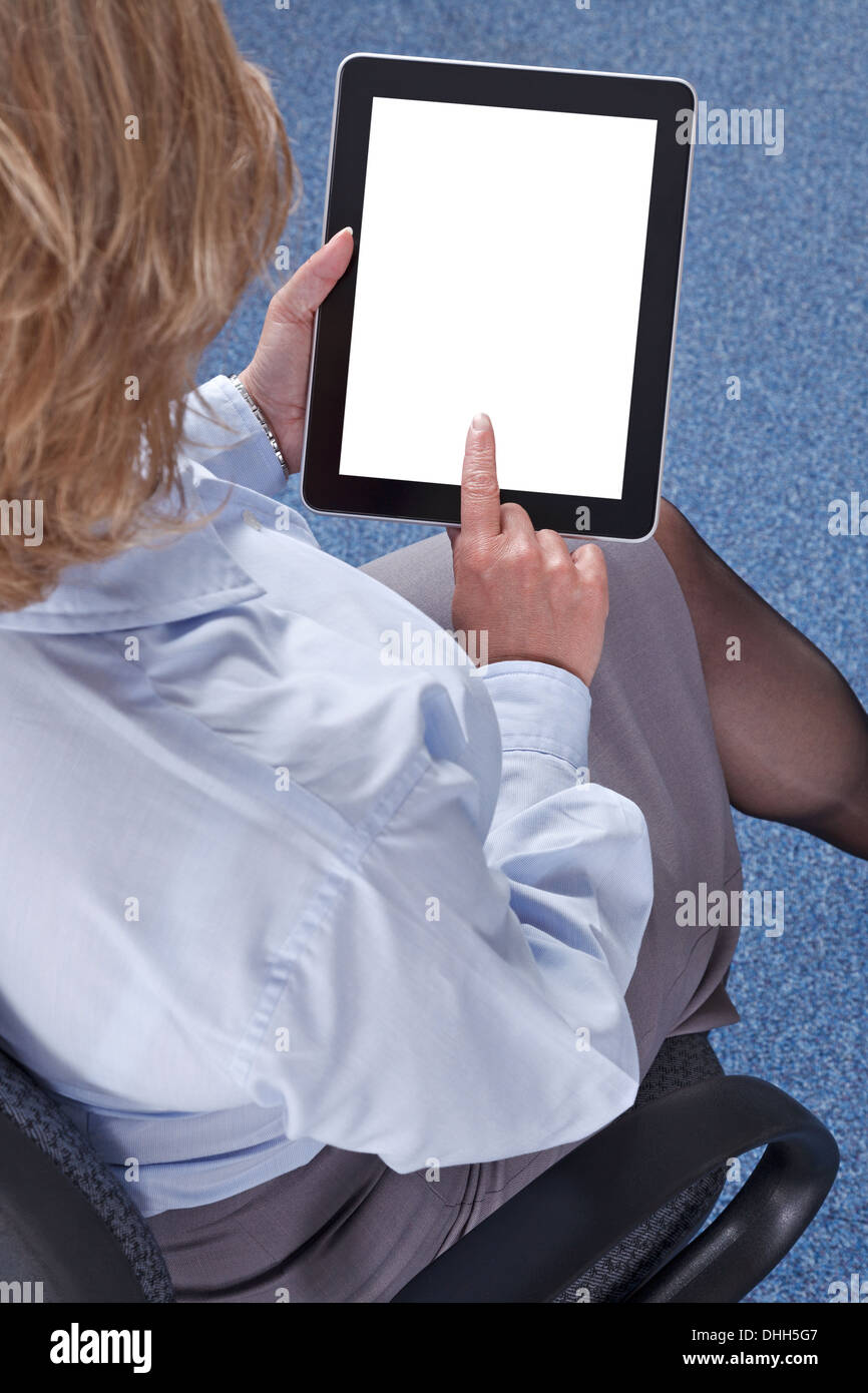 Businesswoman sat in an office using a tablet computer. Clipping path ...