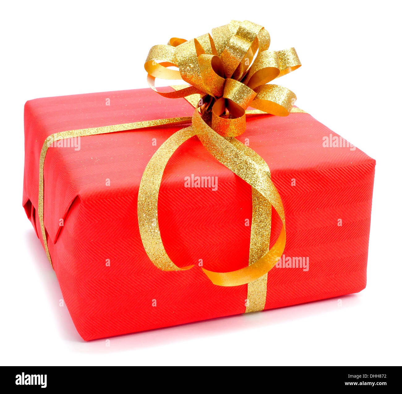 a gift wrapped with red wrapping paper and with a golden ribbon on a ...