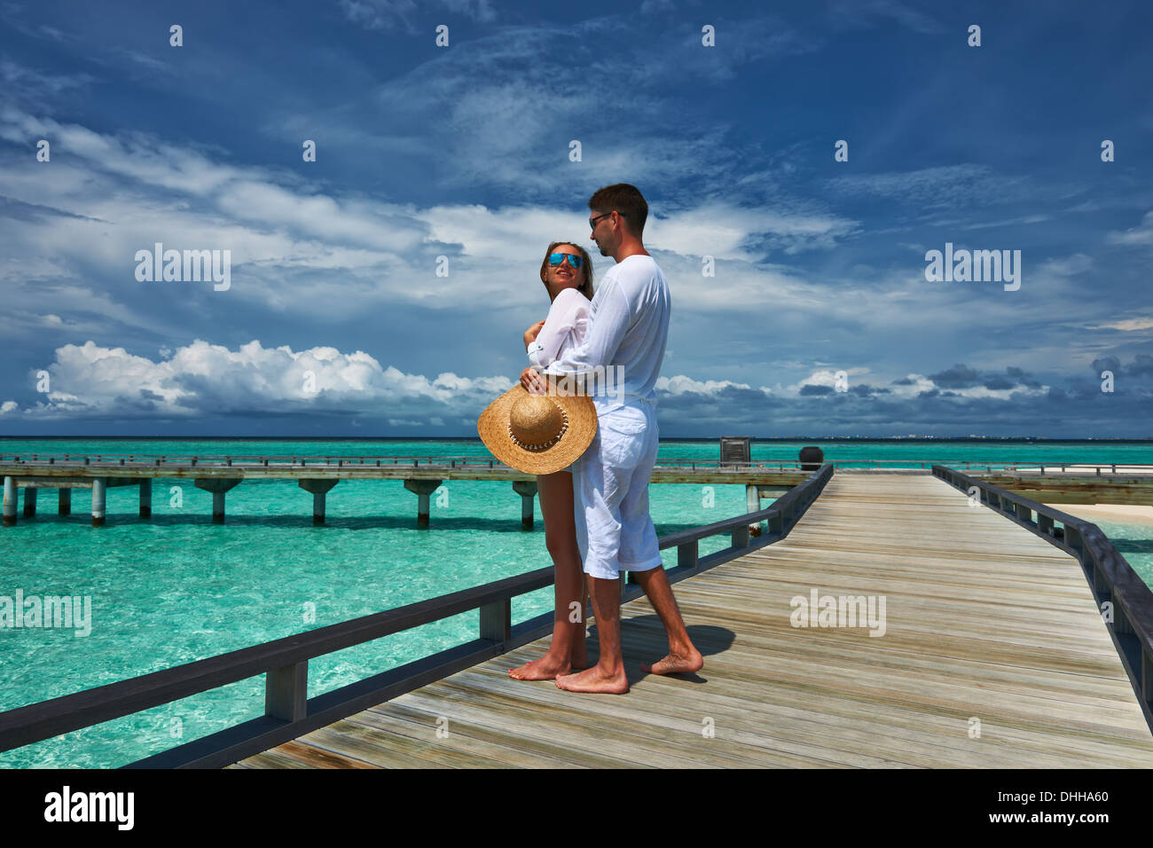 Couple on a beach jetty at Maldives Stock Photo - Alamy