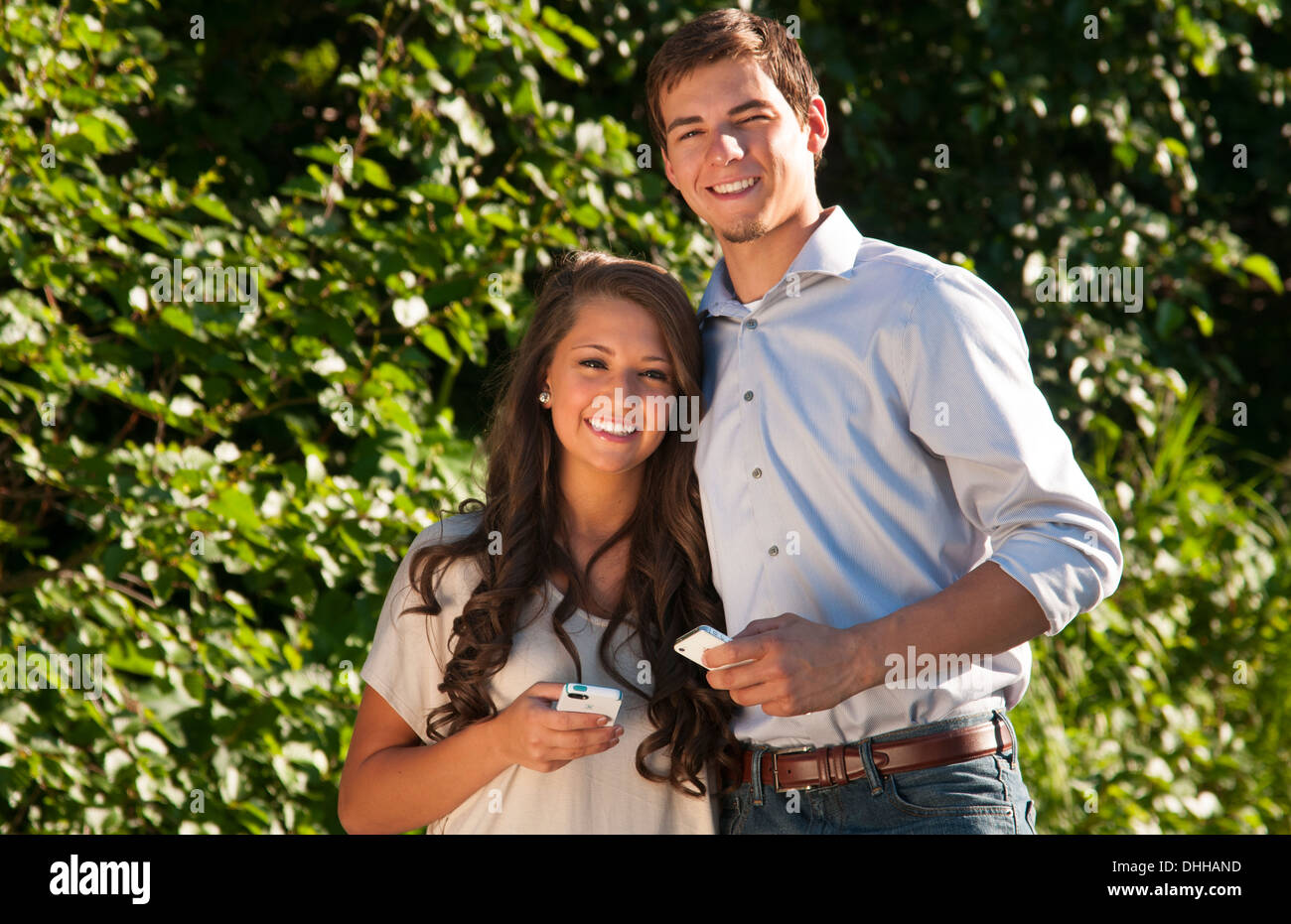 Young teenagers dating boy and girl aged 17 texting on Iphone together ...