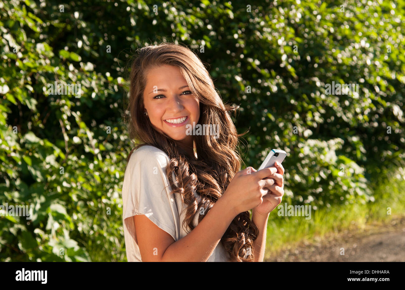 Young teenager girl age 17 texting on Iphone happy home outdoors ...