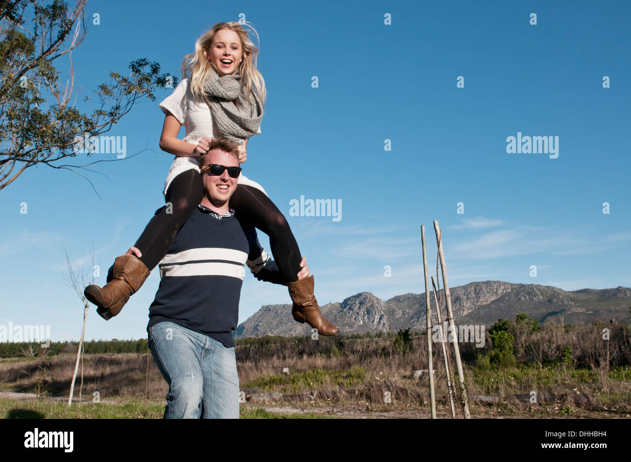 Young womans sitting on boyfriend's shoulders Stock Photo - Alamy