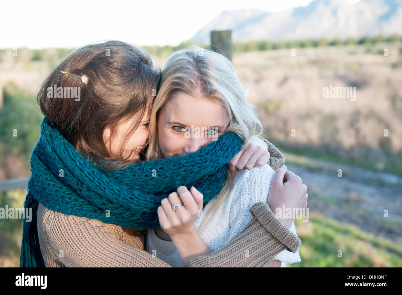 Two young women wearing knitted scarf Stock Photo - Alamy