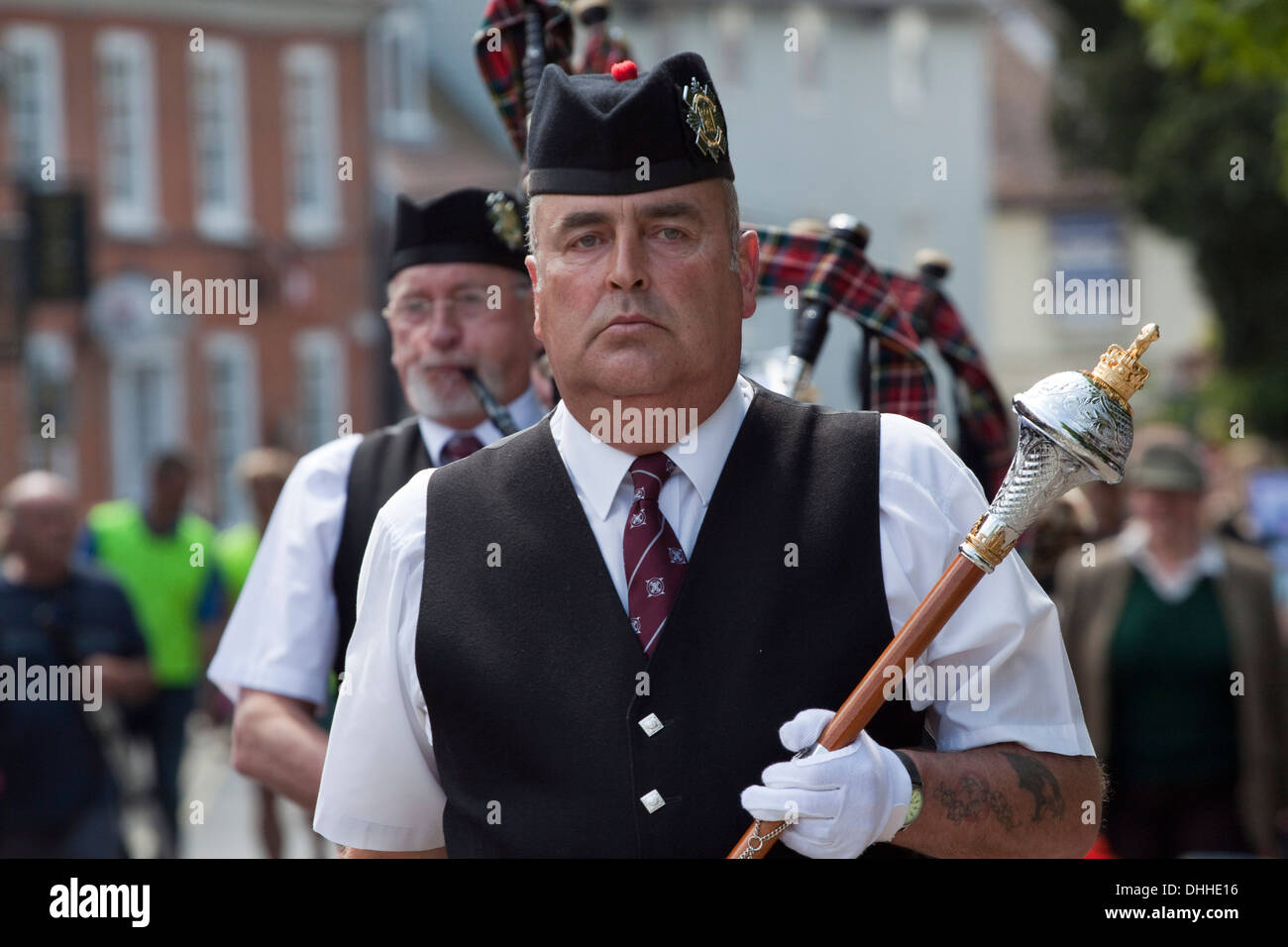 Dour looking drum major leads Scottish bagpipe band marching in the ...