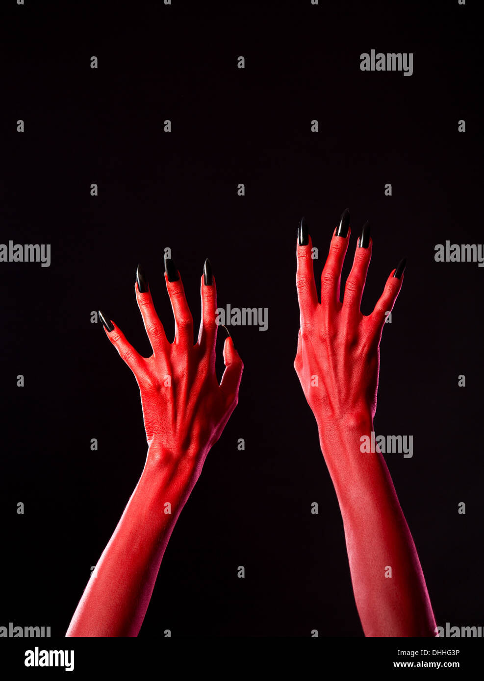 Red spooky devil hands with black nails, Halloween theme, studio shot ...