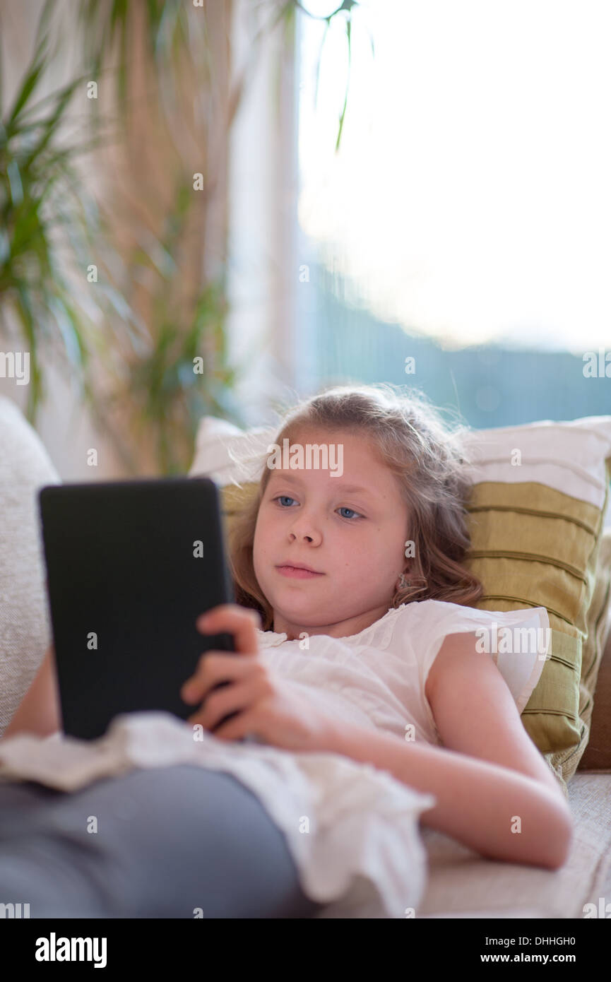 girl on a sofa using an ipad tablet computer Stock Photo - Alamy