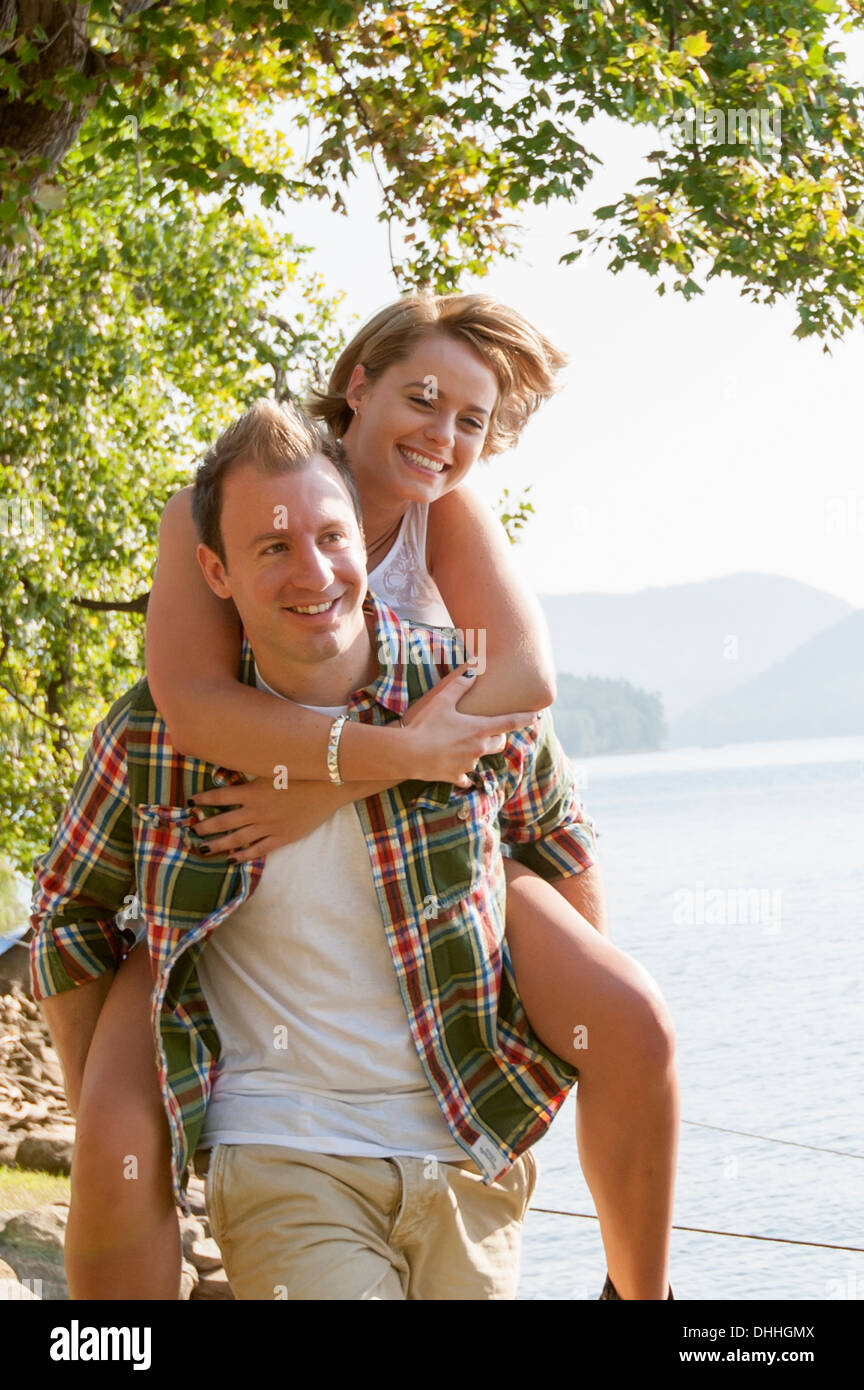 Young man giving woman piggy back Stock Photo - Alamy