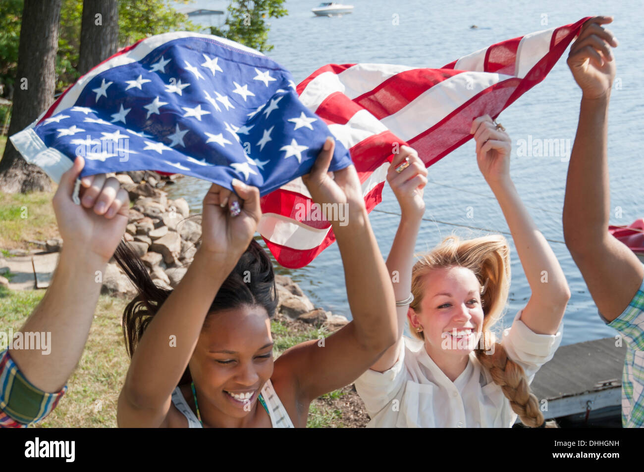 Friends holding US flag above heads, smiling Stock Photo - Alamy