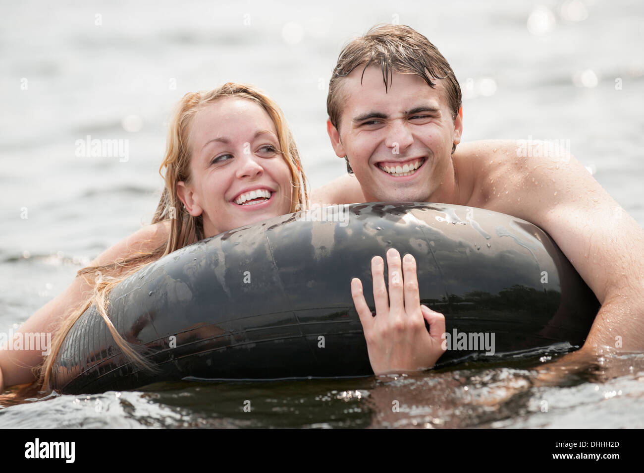 Young couple floating in inflatable ring Stock Photo - Alamy