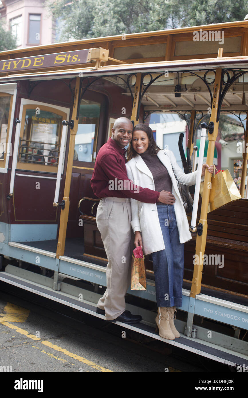 Couple of cute African American yuppies grab a cable car to get home to ...