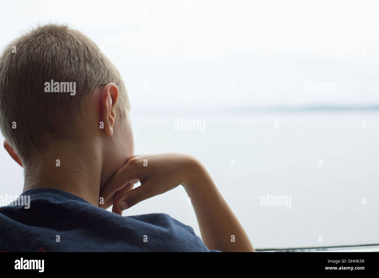 Boy looking through window hi-res stock photography and images - Alamy
