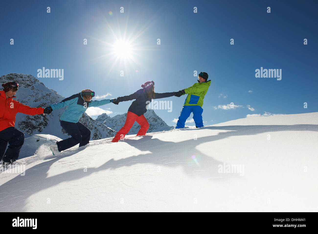Friends pulling each other uphill in snow, Kuhtai, Austria Stock Photo ...