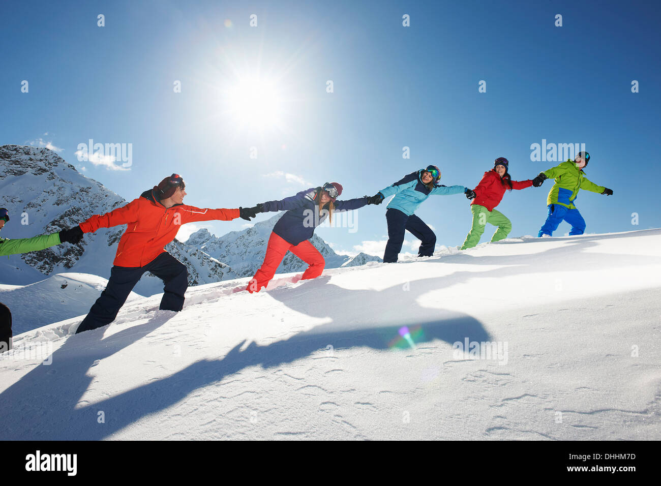 Friends pulling each other uphill in snow, Kuhtai, Austria Stock Photo ...