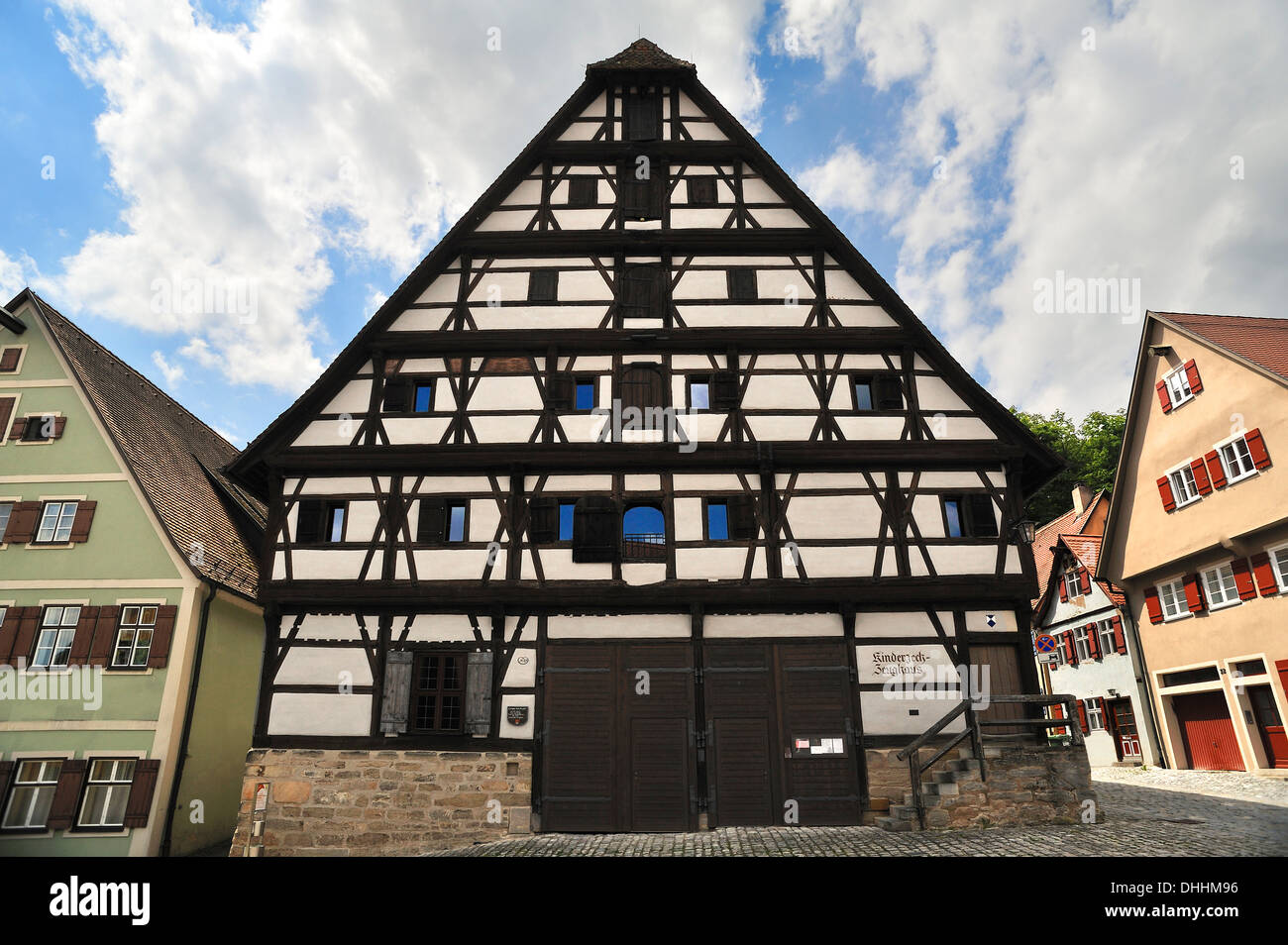 Two-storey half-timbered building on a stone plinth with a steep hipped ...