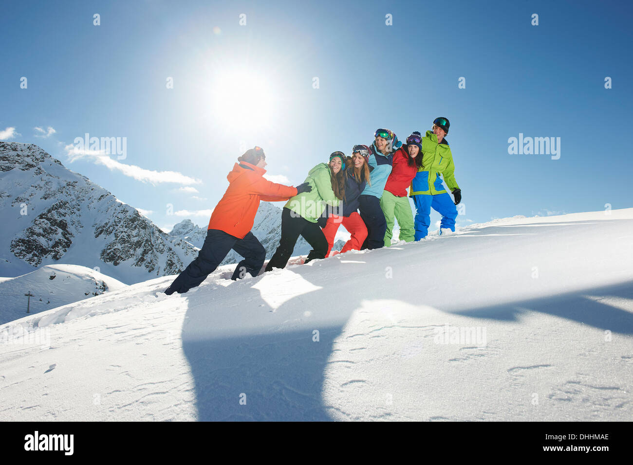 Man pushing friends uphill in snow, Kuhtai, Austria Stock Photo - Alamy