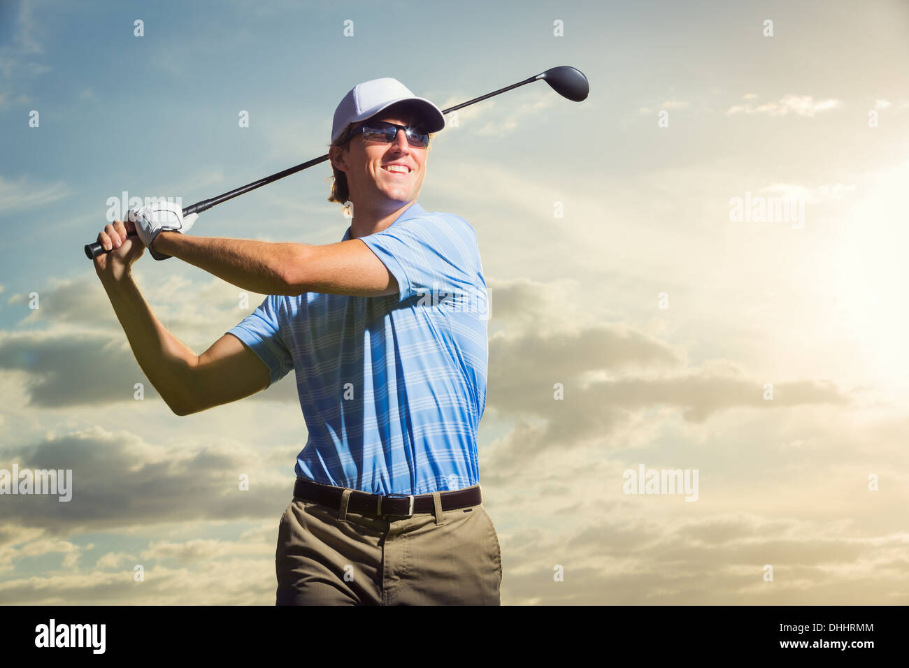 Golfer at sunset, Man swinging golf club with dramatic sunset sky ...