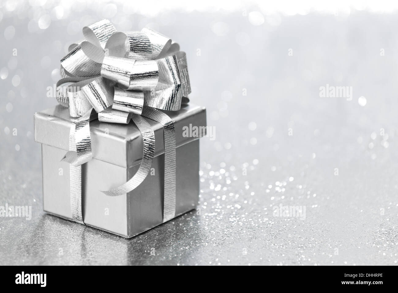 Silver holiday gift on glitter background Stock Photo - Alamy