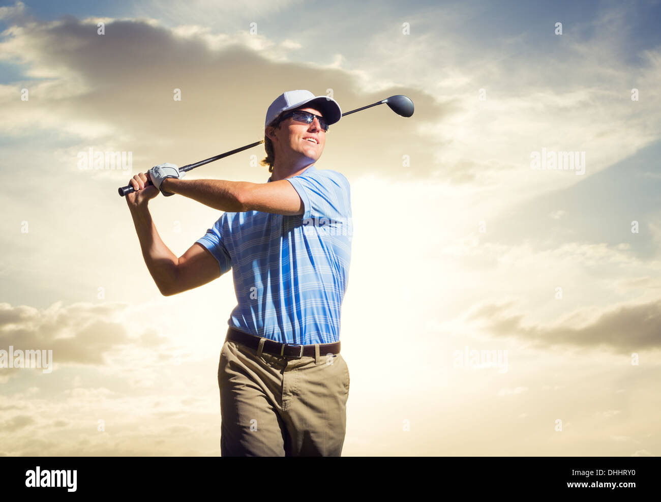 Golfer at sunset, Man swinging golf club with dramatic sunset sky ...