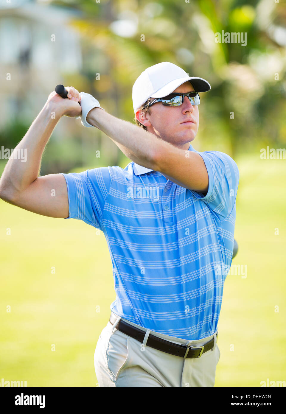 Young man swinging golf club Stock Photo - Alamy
