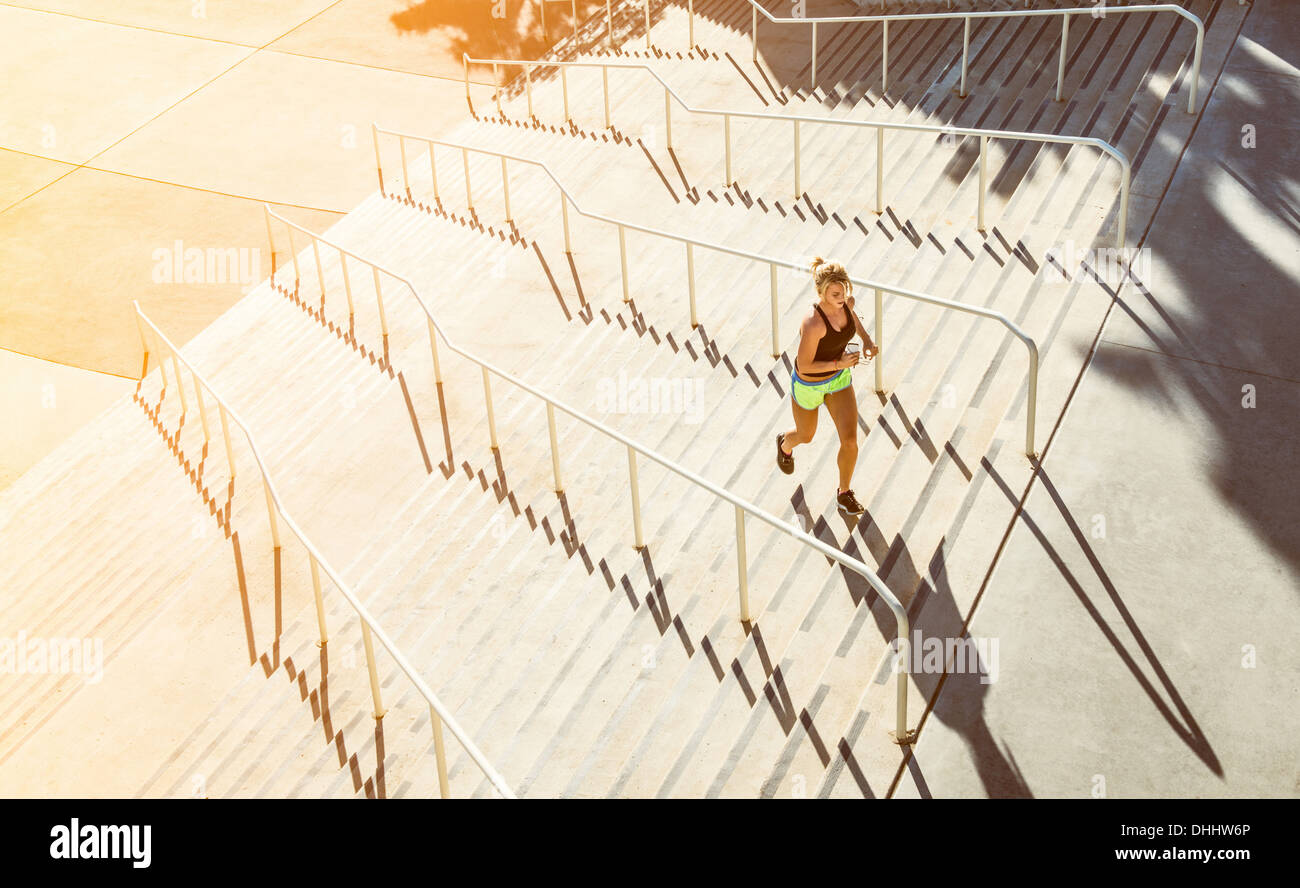 Woman running up stairs Stock Photo - Alamy