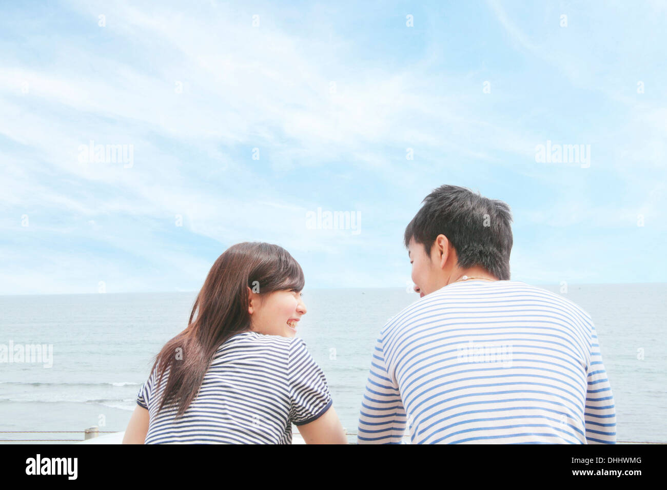 Rear view of couple at coast, face to face and laughing Stock Photo - Alamy