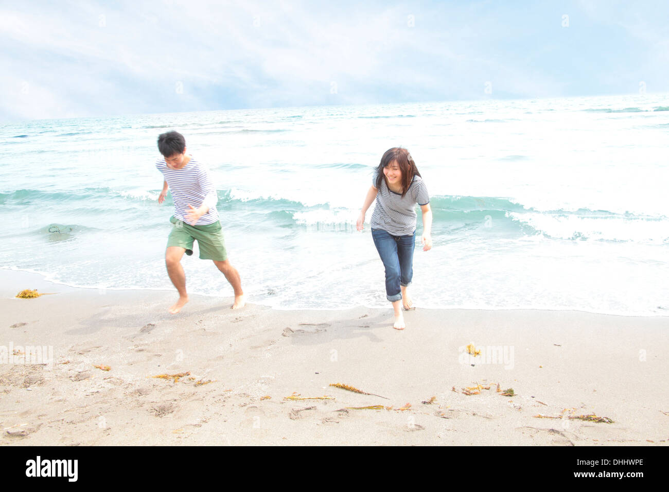 Young man running into waves hi-res stock photography and images - Alamy