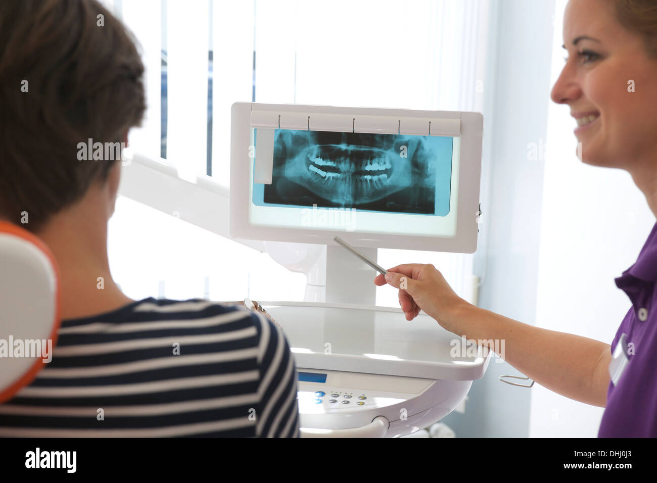 Patient looking at xray of dental implants Stock Photo - Alamy