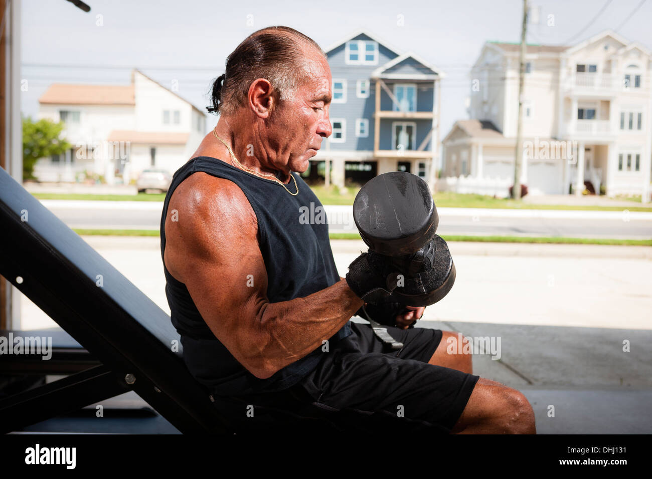 Portrait of muscular senior man lifting dumb bells Stock Photo - Alamy